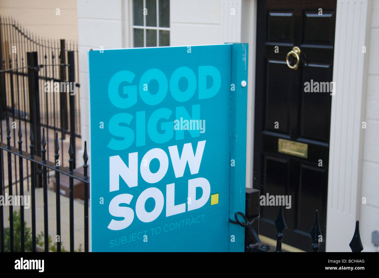 Estate agent sold sign outside a new house with the front door visible ...
