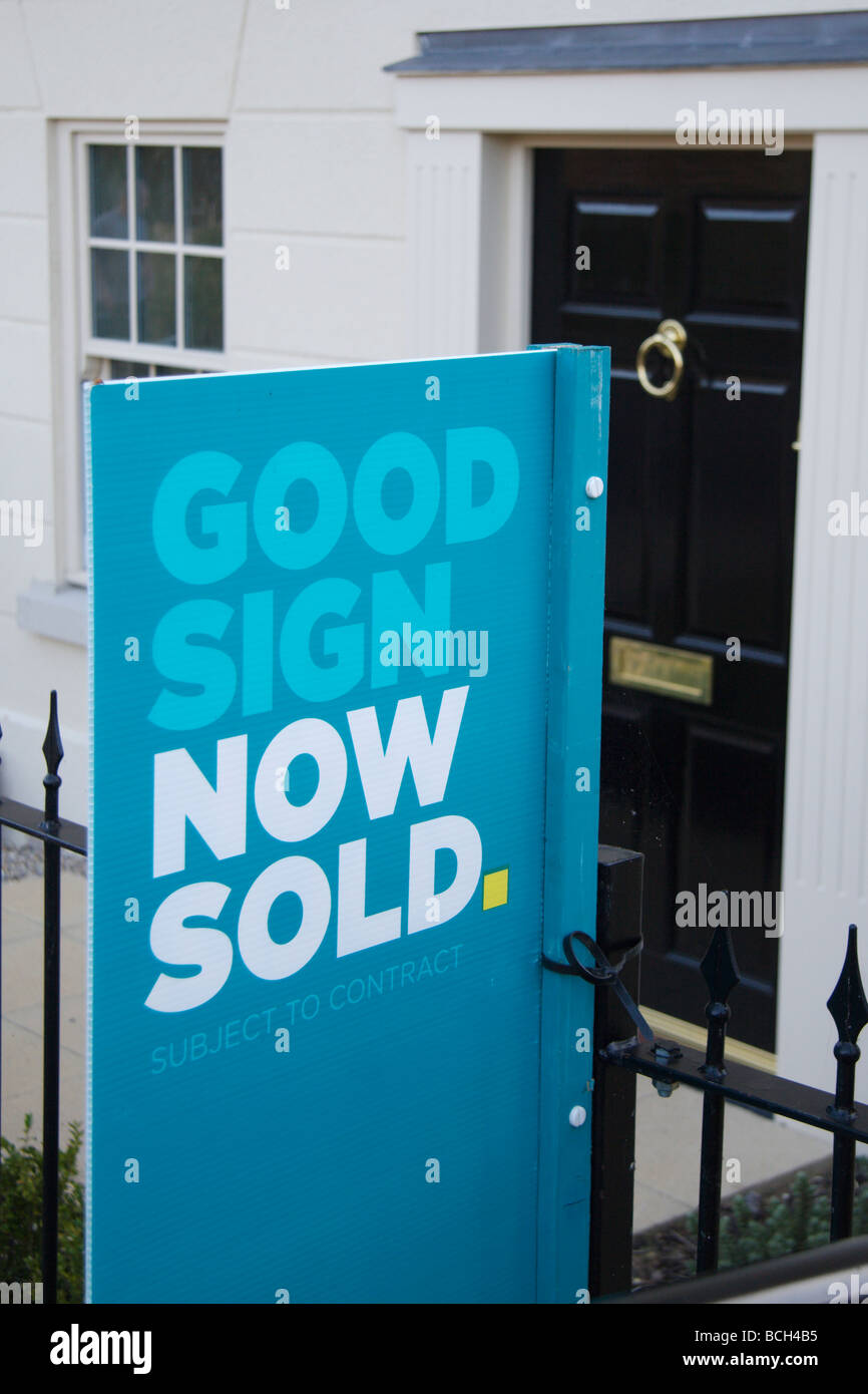 Estate agent sold sign outside a new house with the front door visible ...