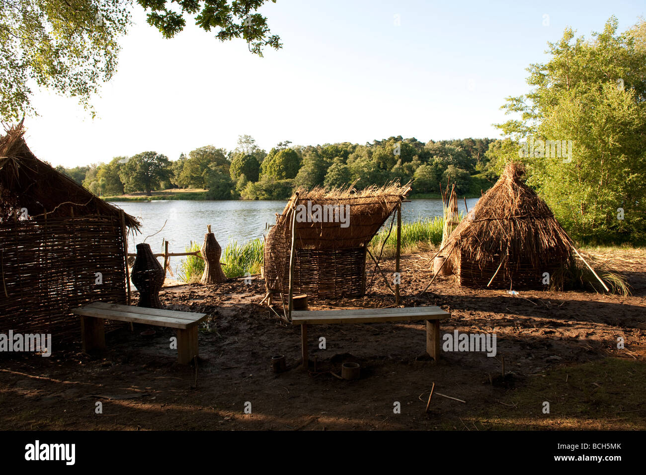 Primative living in stick and reed huts by a lake Stock Photo - Alamy