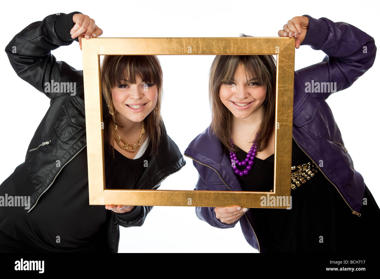 Twin girls holding a picture frame isolated against white Stock Photo ...
