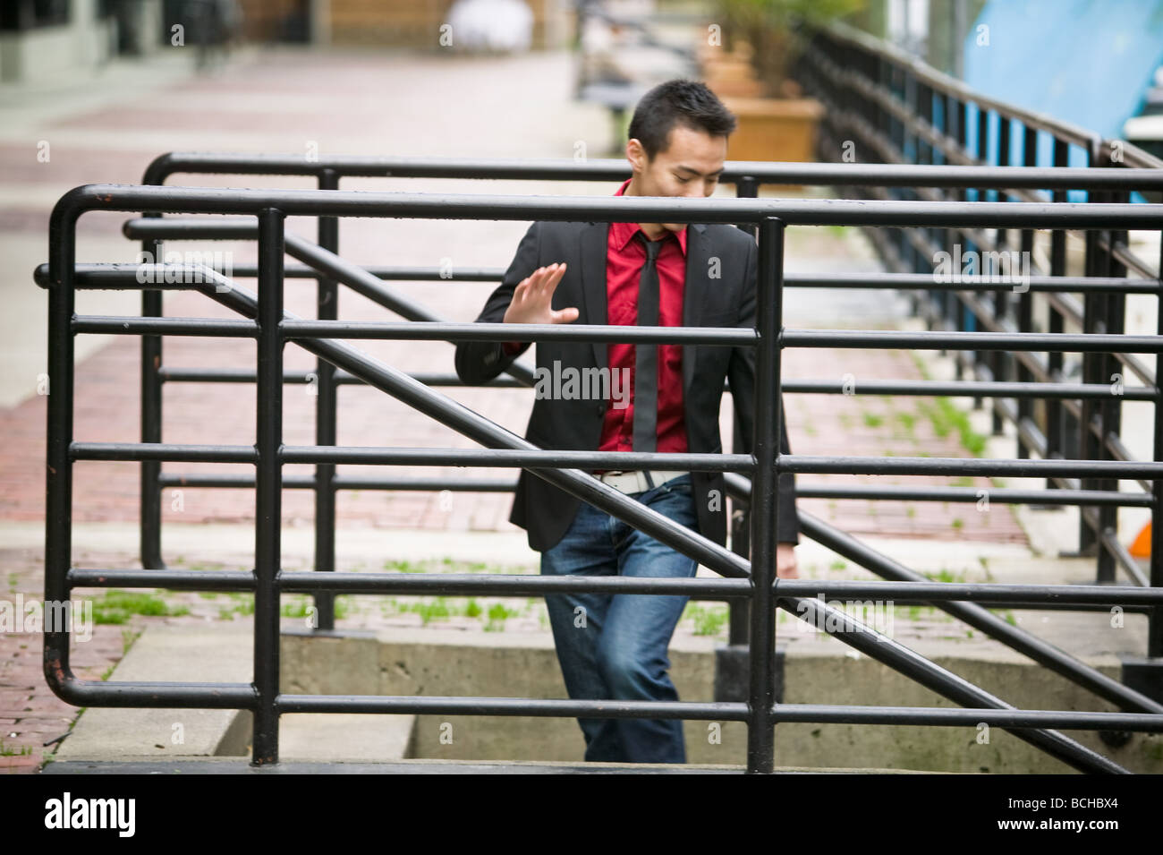 Young Asian man walking up a set of stairs Stock Photo - Alamy
