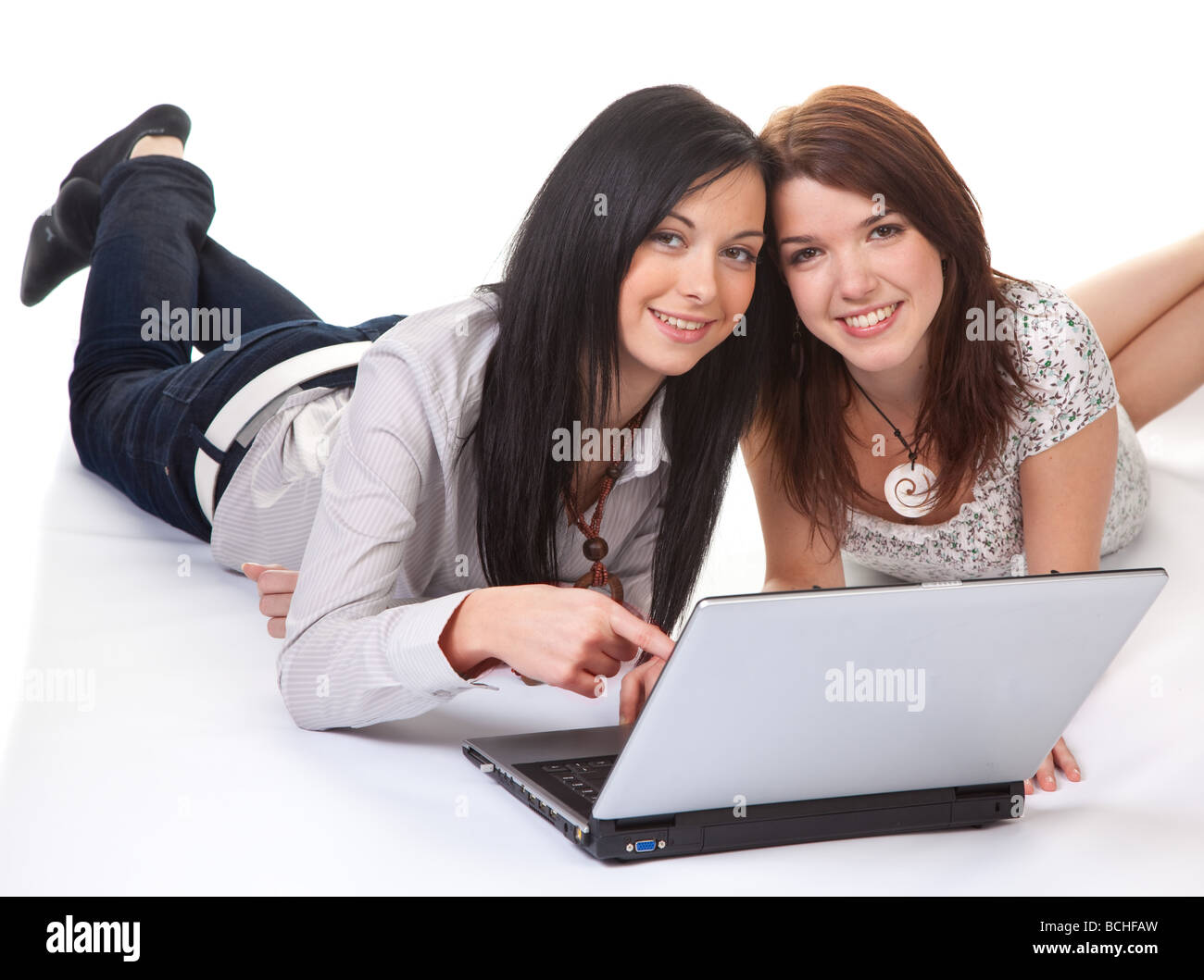 Young girls laughing and working together on a laptop Stock Photo - Alamy
