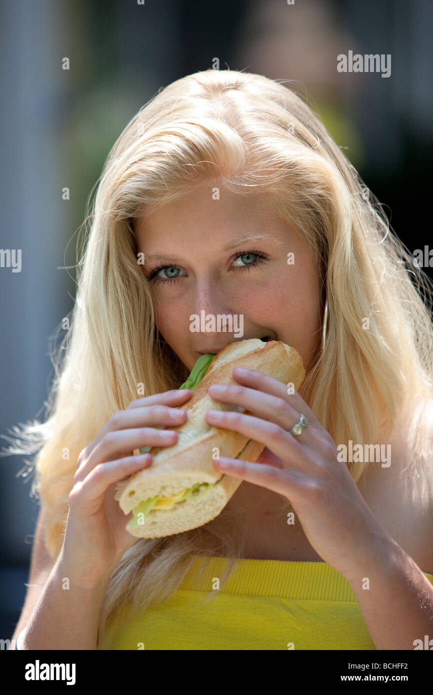 Teenage girl is eating a sandwich Stock Photo - Alamy