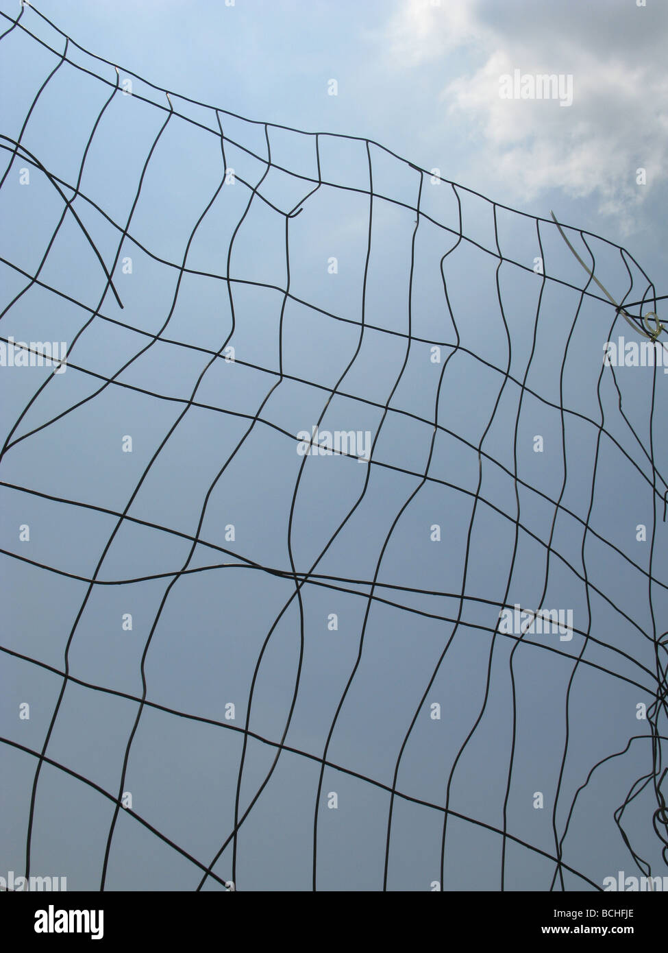 damaged metal wire fence and dark sky outdoors Stock Photo - Alamy