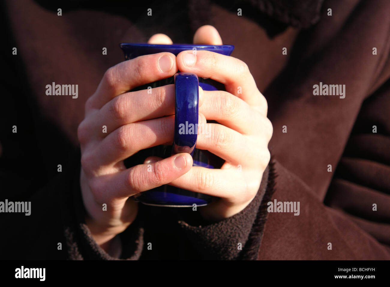 Woman holding warm punch to warm her hands Stock Photo - Alamy