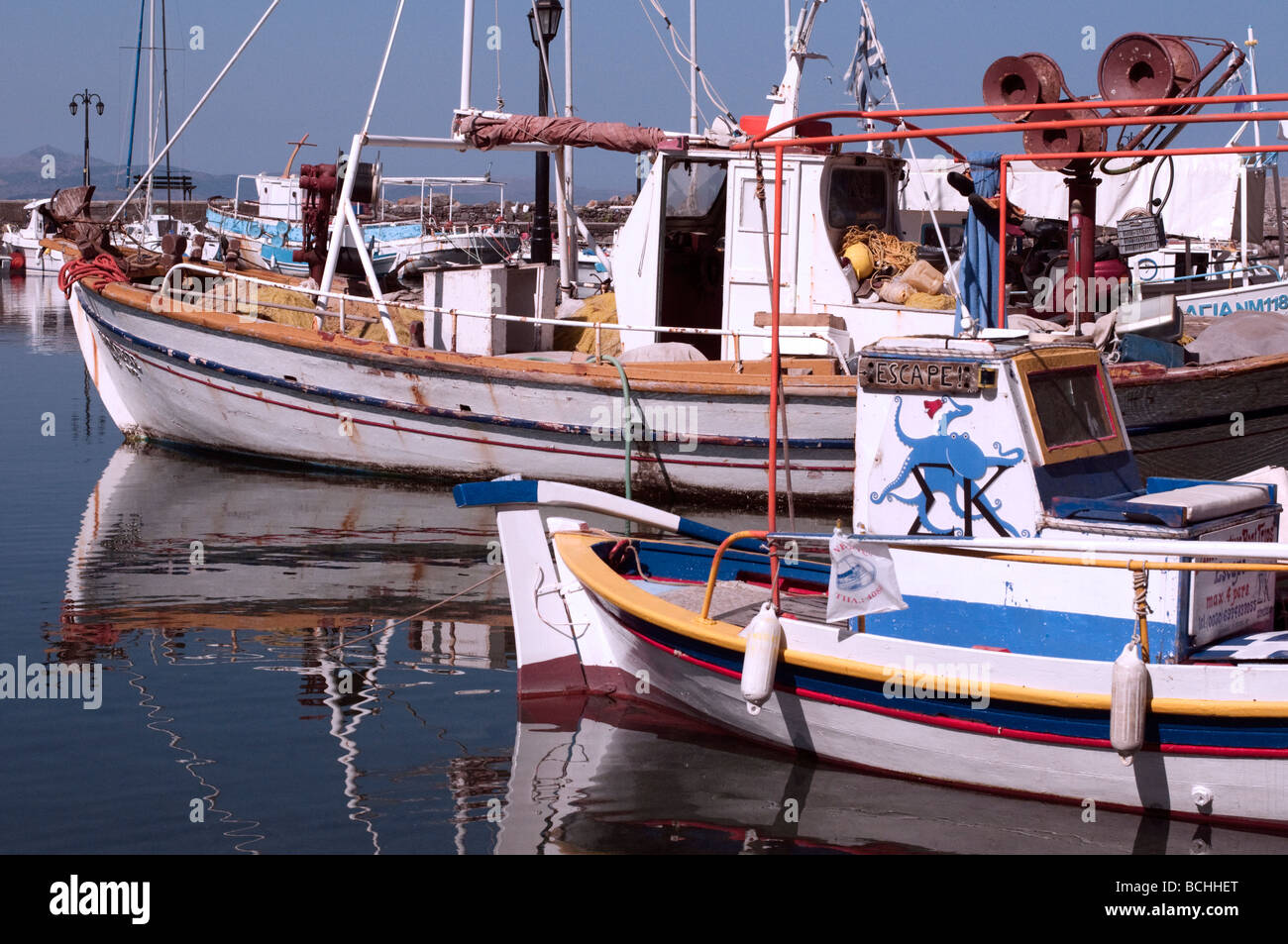 Greek fishing boats reflected in the water of the harbor Stock Photo ...