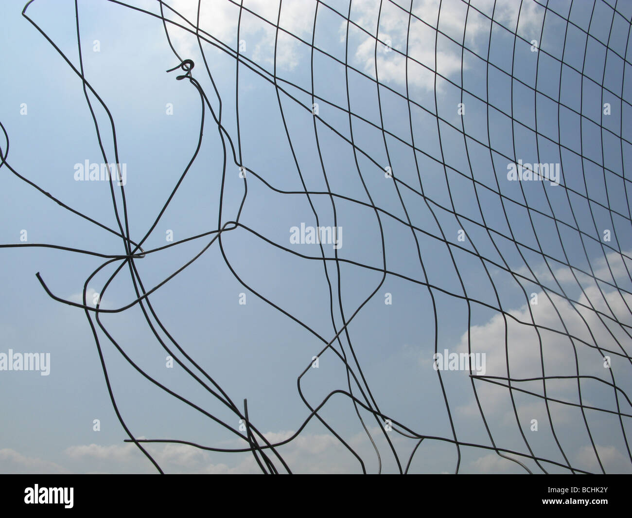 damaged metal wire fence and dark sky outdoors Stock Photo - Alamy