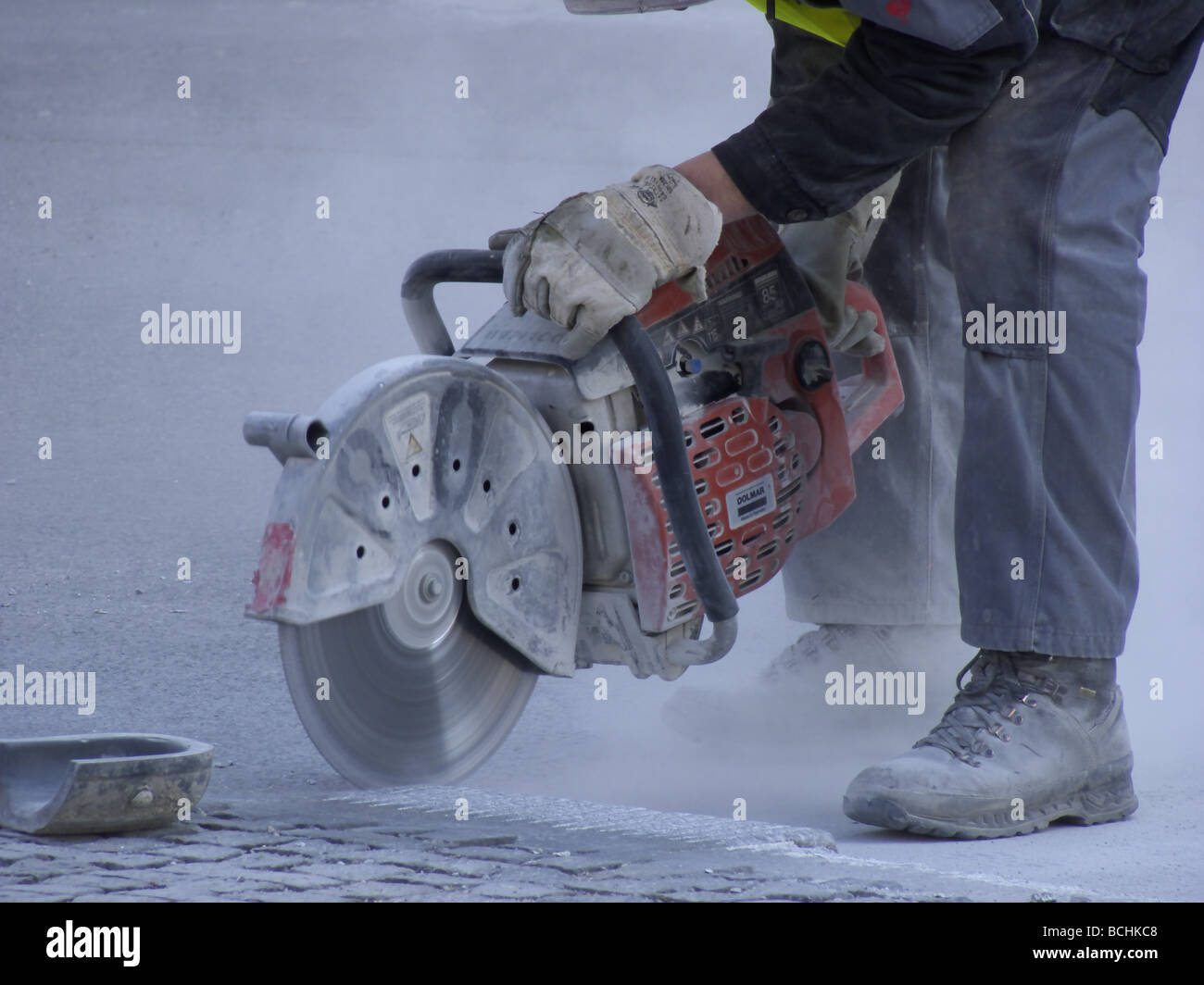 Construction worker cutting the pavement with heavy machine Stock Photo ...