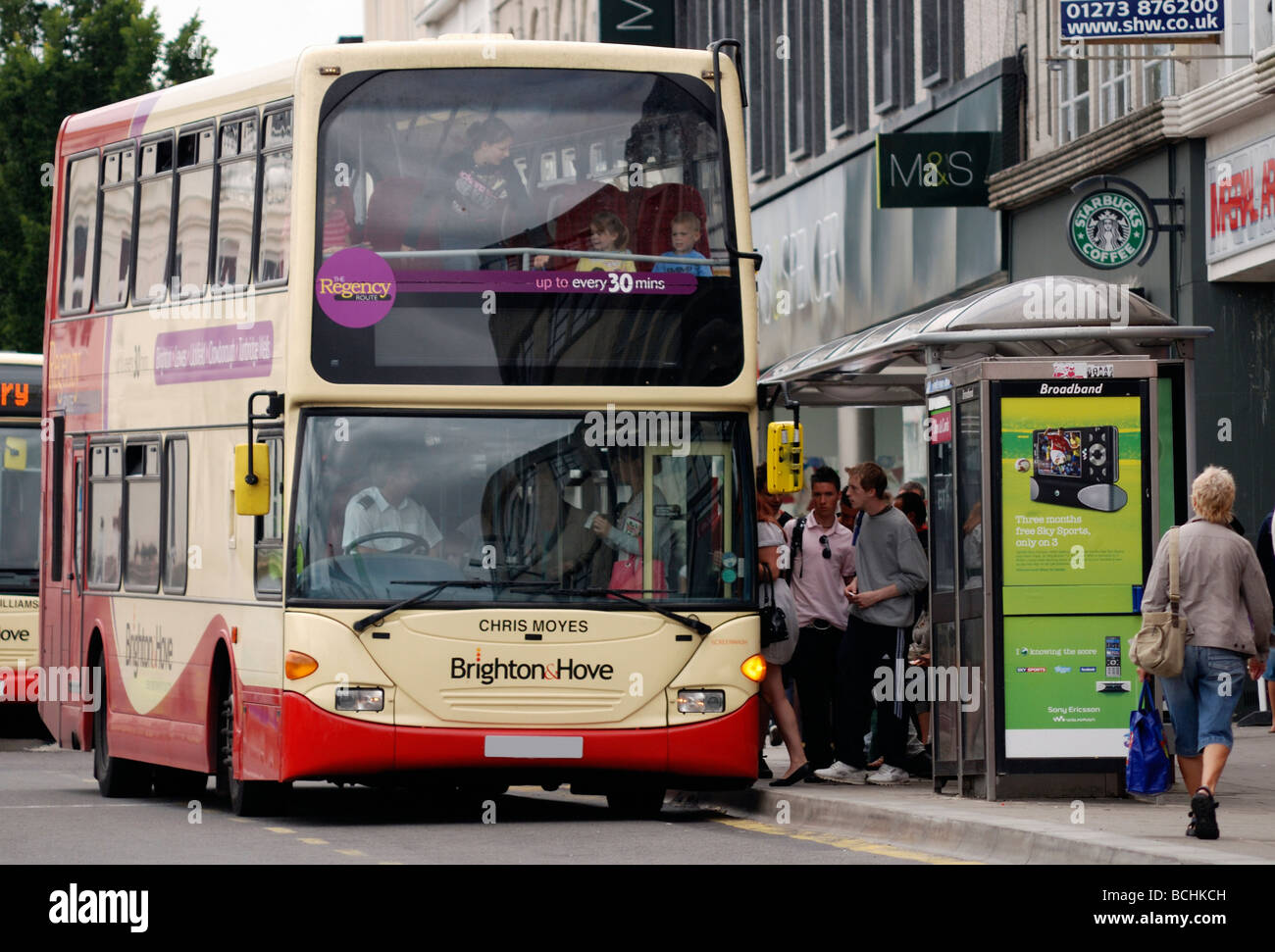 Double decker bus pulling into busy bus stop Stock Photo - Alamy