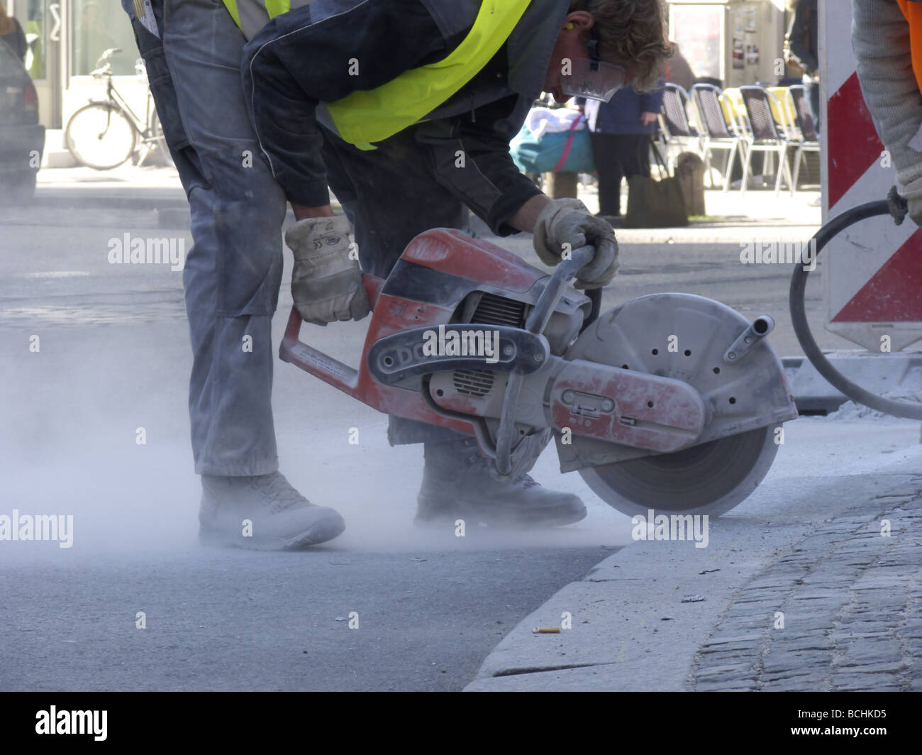Construction worker cutting the pavement with heavy machine Stock Photo ...