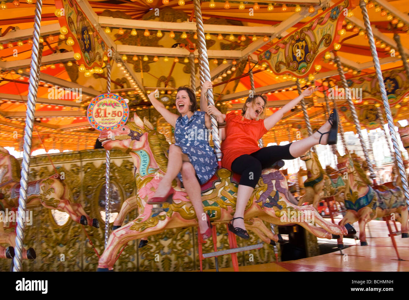 Girls riding merry go round hi-res stock photography and images - Alamy