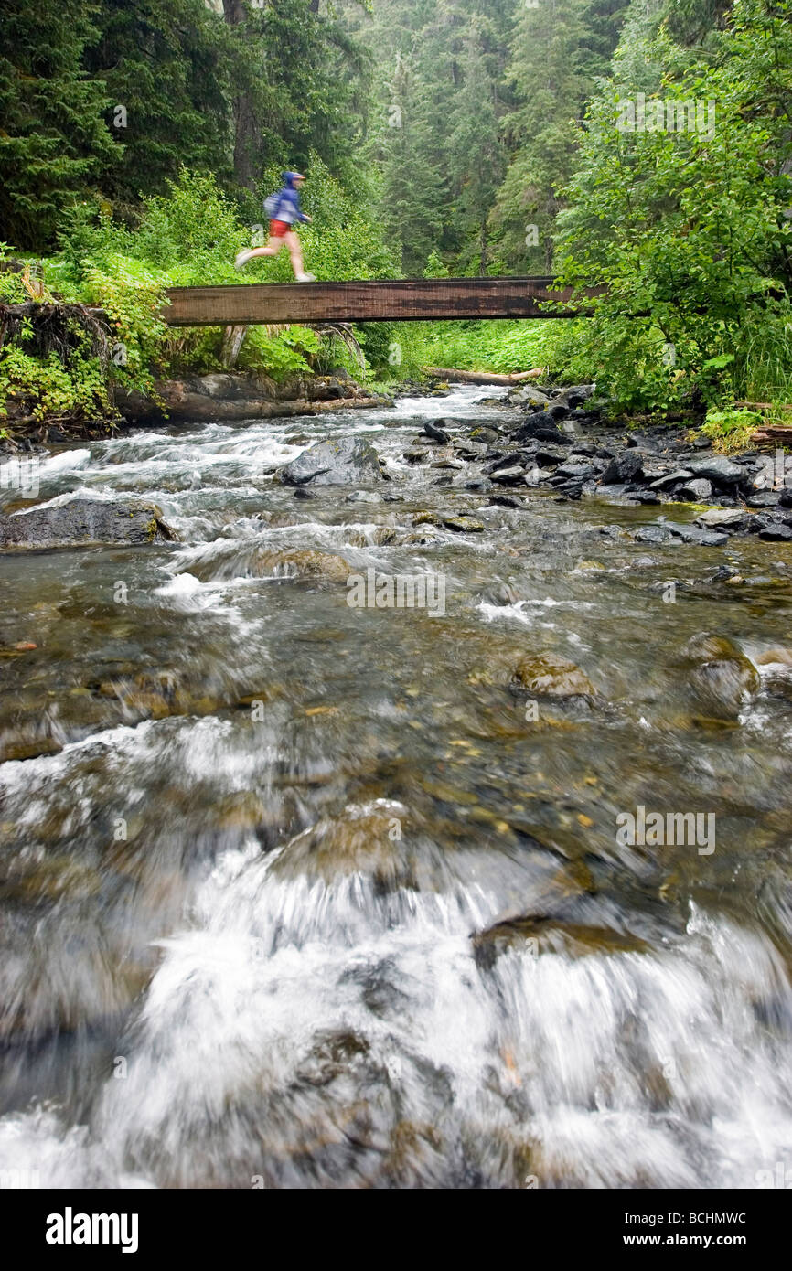 Female runner crossing a bridge while running the Resurrection River ...