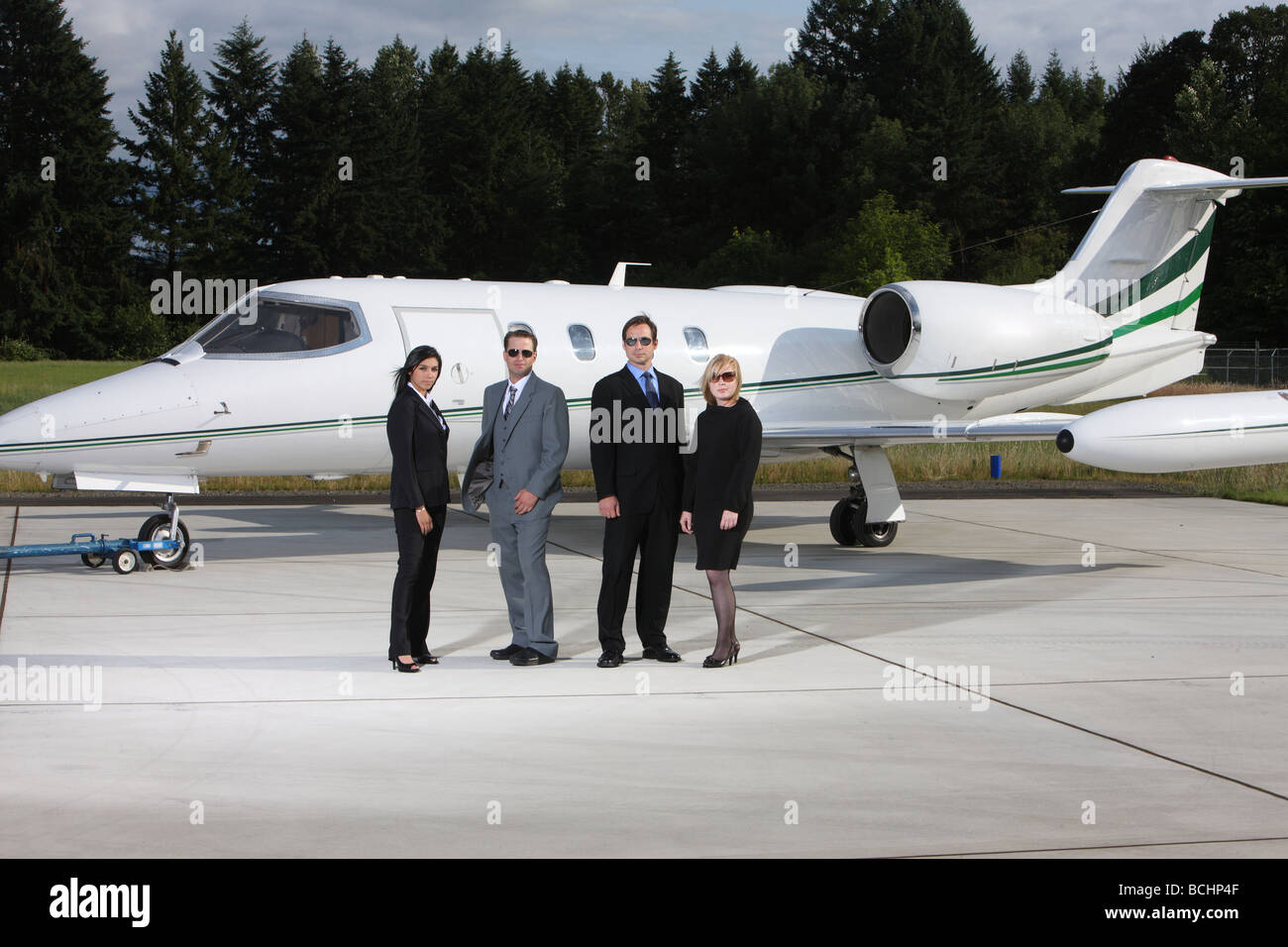 Group of business people with corporate jet in background Stock Photo ...