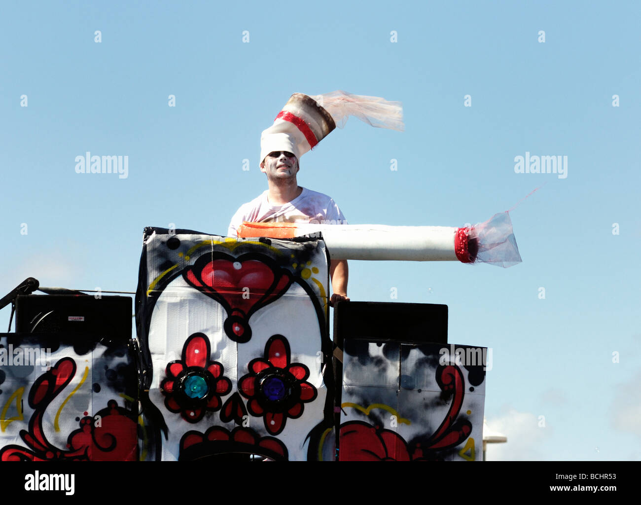 Man dressed as cigarette holding large cigarette on float in street ...