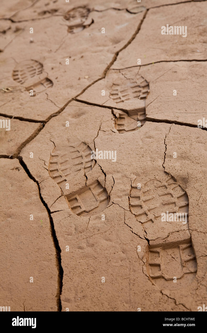 Environmental concept shot showing bootprints going across cracked dry ...