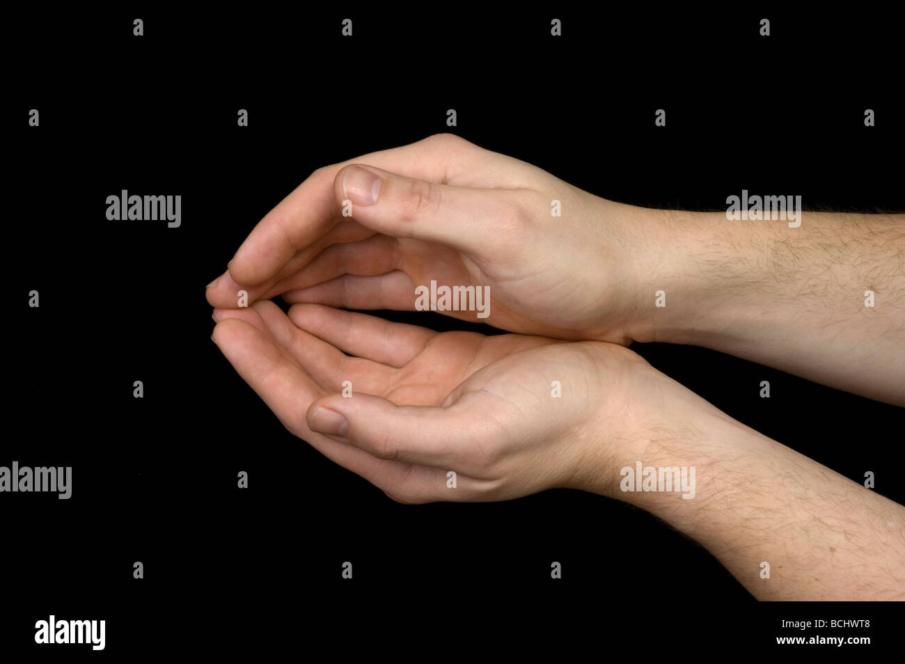 male hands enclosing and encompassing and cupping against black Stock ...