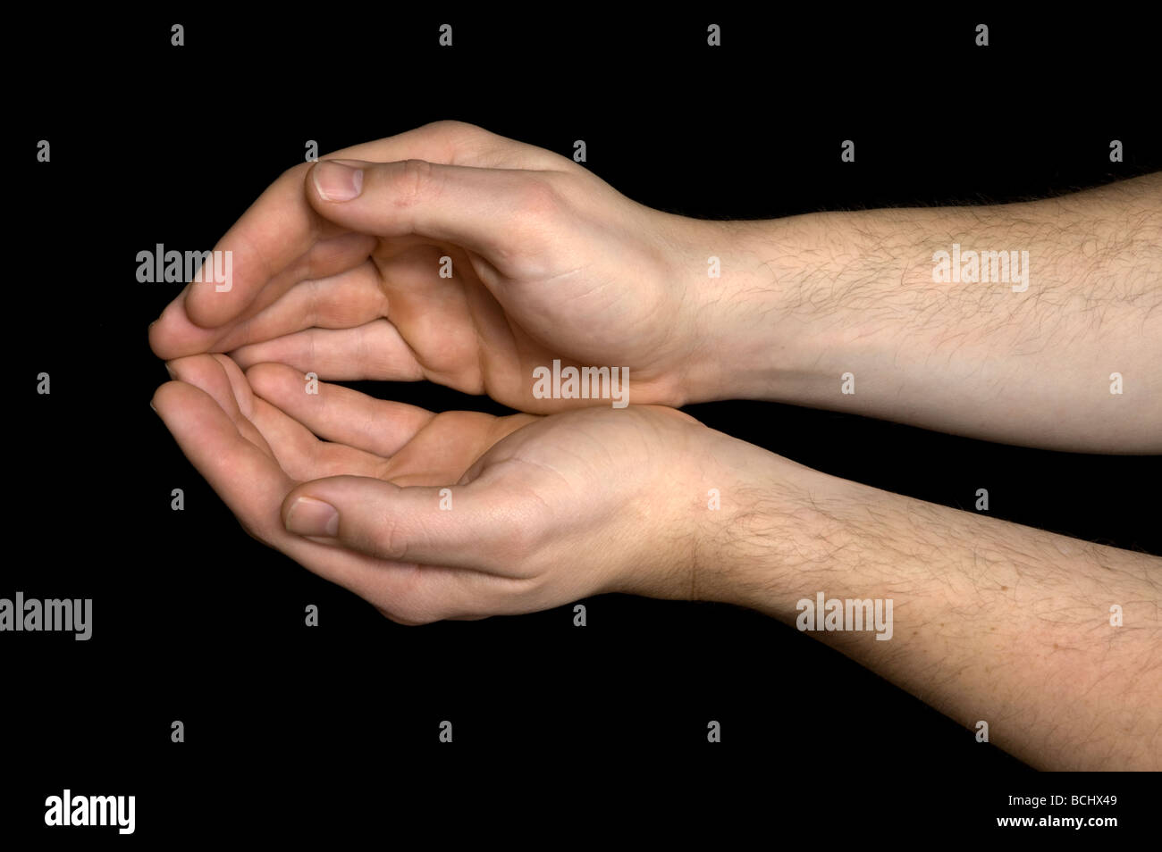 male hands enclosing and encompassing and cupping against black Stock ...