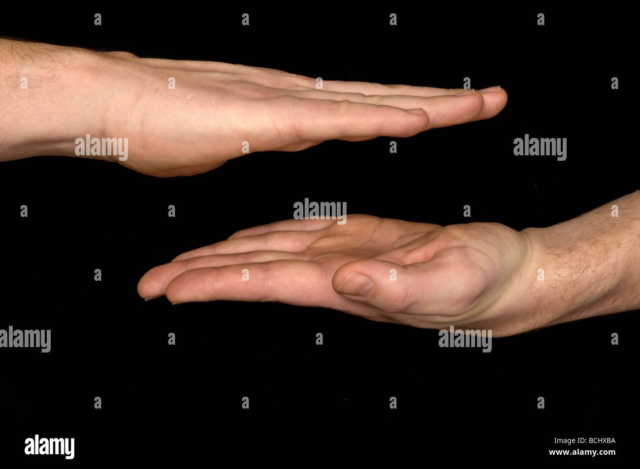 male hands enclosing and encompassing and cupping against black Stock ...