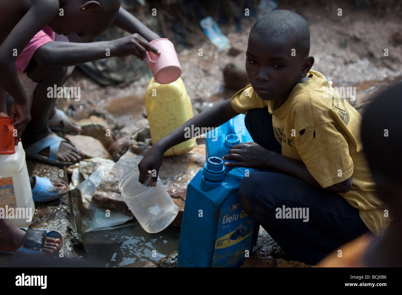 Children collecting water from contaminated spring. Kamwockya Kampala ...