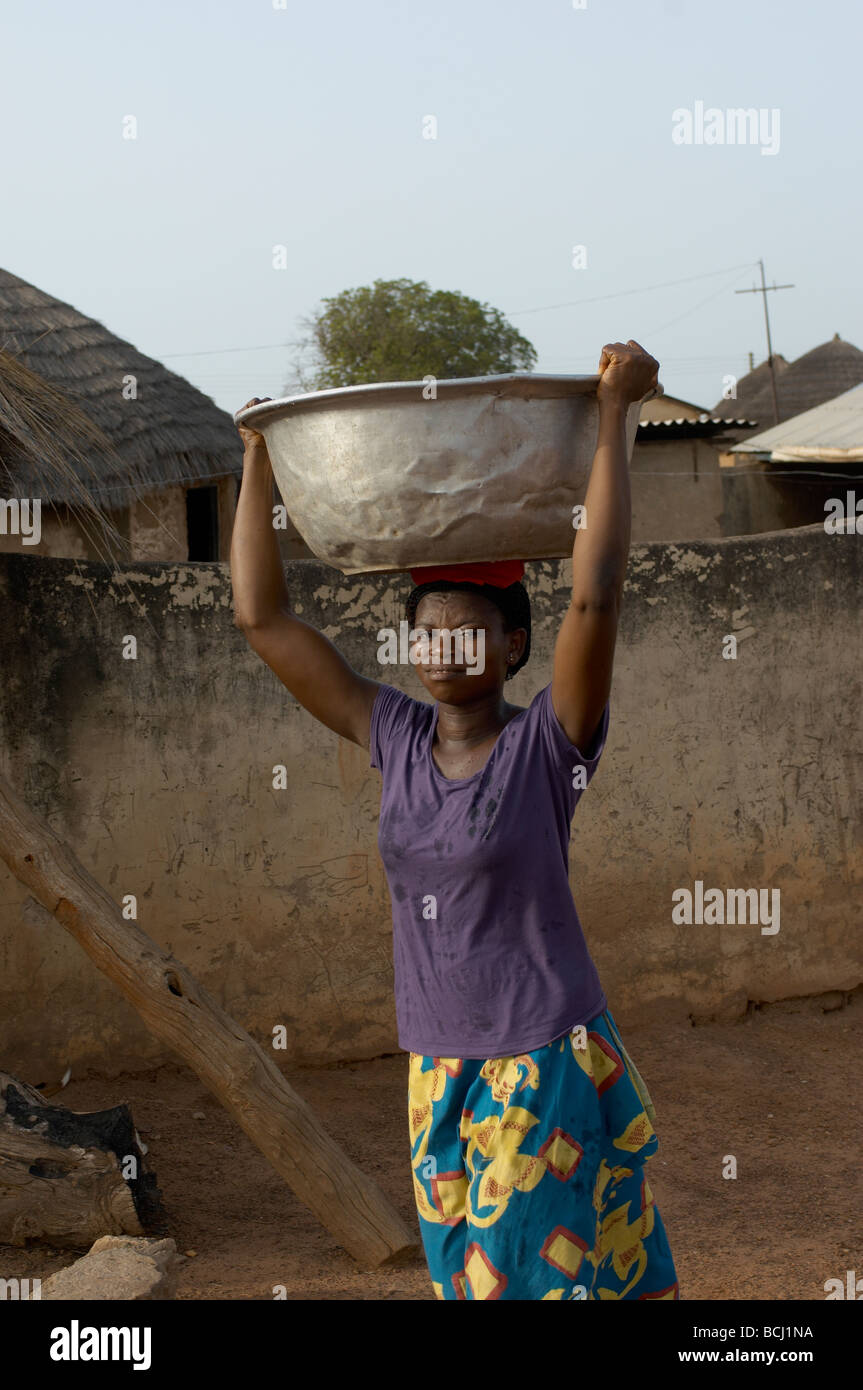Women collecting water from water hole on heads in village in Tamale ...