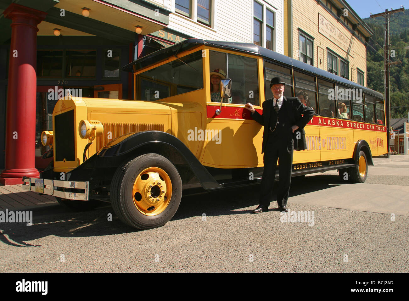 Man poses in front of a yellow *Skagway Street Car* during Summer in ...