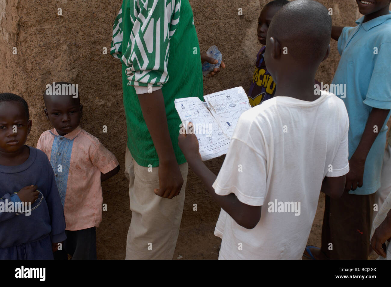 child reading exercise book in street in village in Tamale, Ghana Stock ...