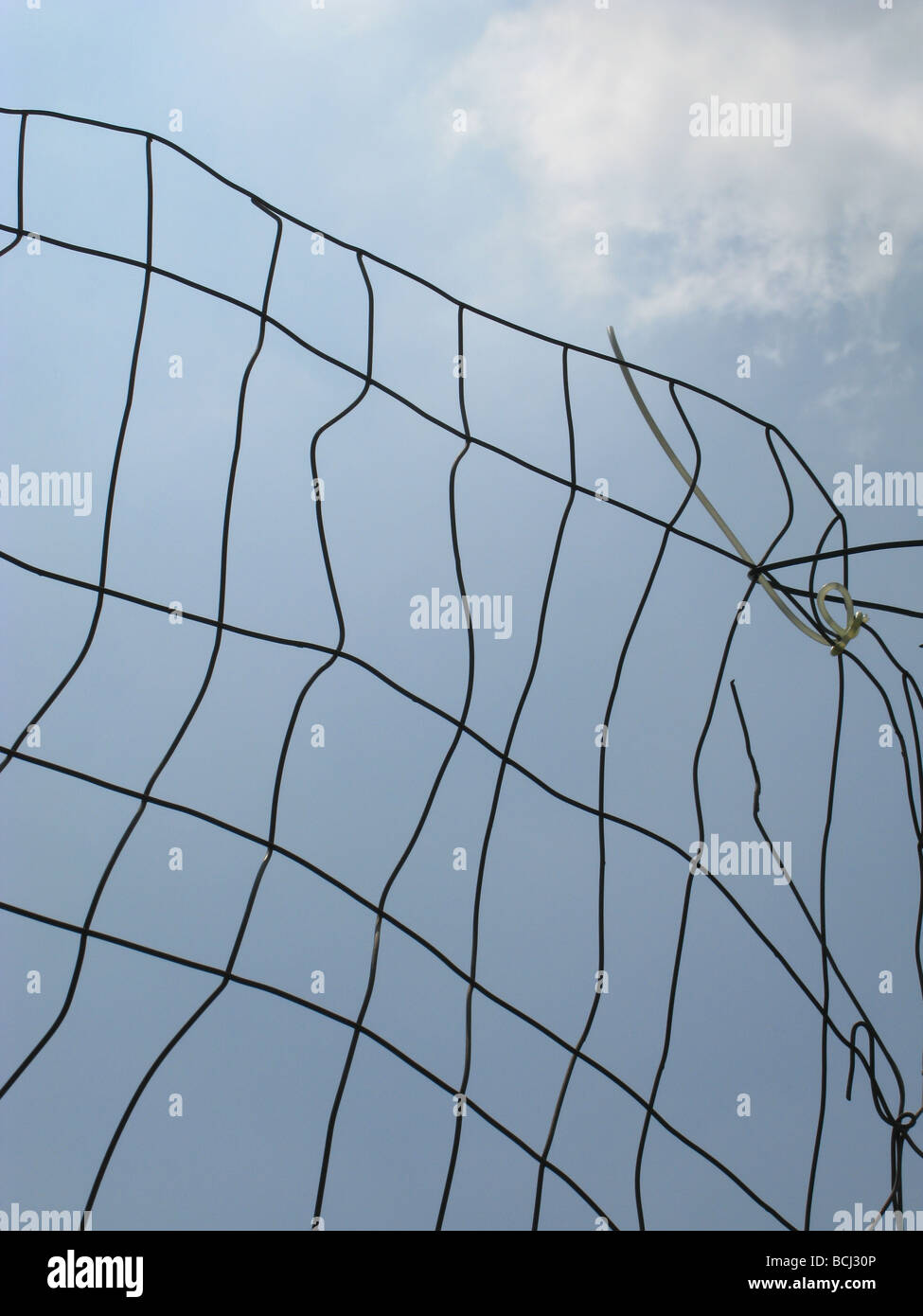 damaged metal wire fence and dark sky outdoors Stock Photo - Alamy