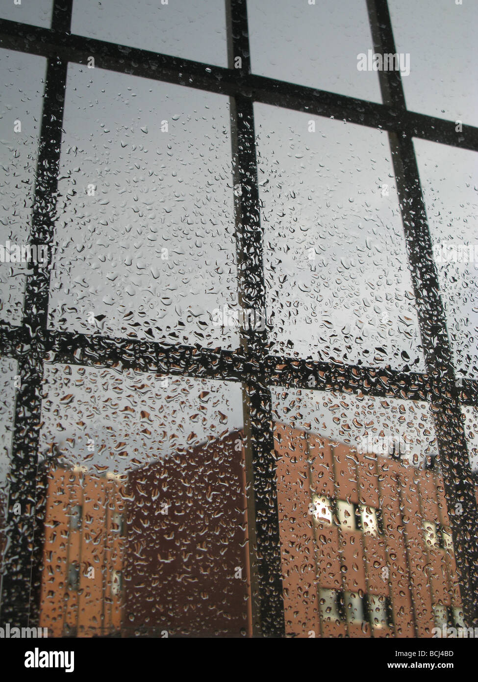 modern office block seen through rain drops covered window Stock Photo ...