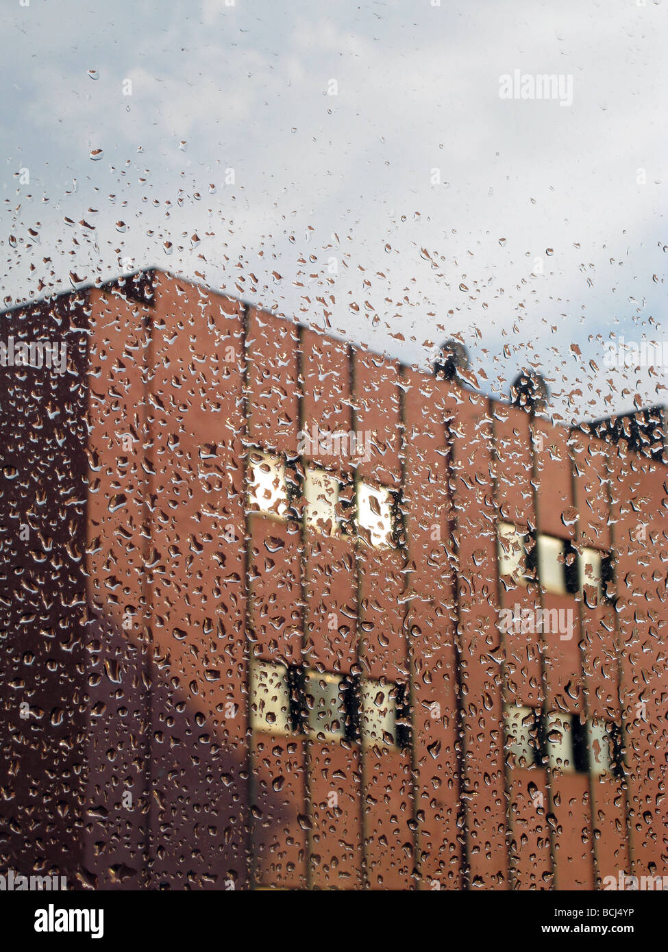 modern office block seen through rain drops covered window Stock Photo ...