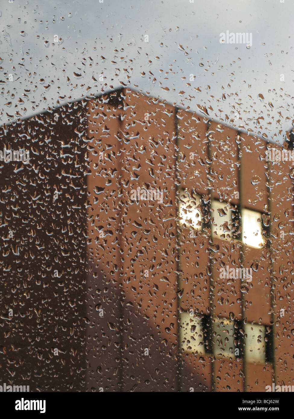 modern office block seen through rain drops covered window Stock Photo ...
