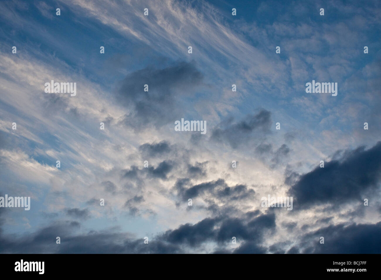 High altitude white clouds with a blue sky and incoming grey clouds ...