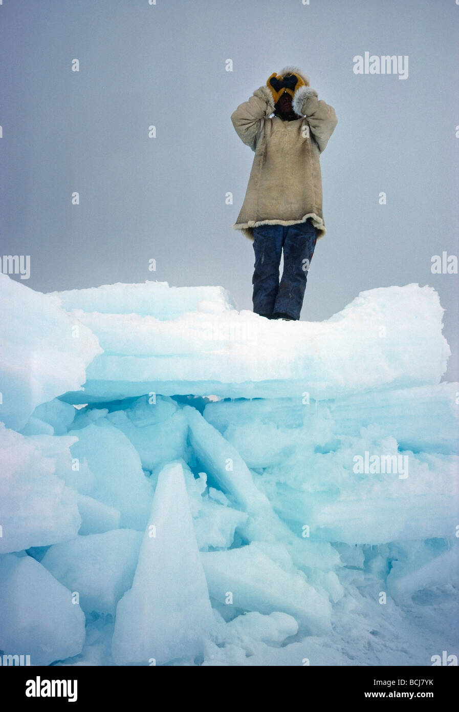 Eskimo Stands on Ice Ridge Viewing Through Binoculars AK AR Spring ...