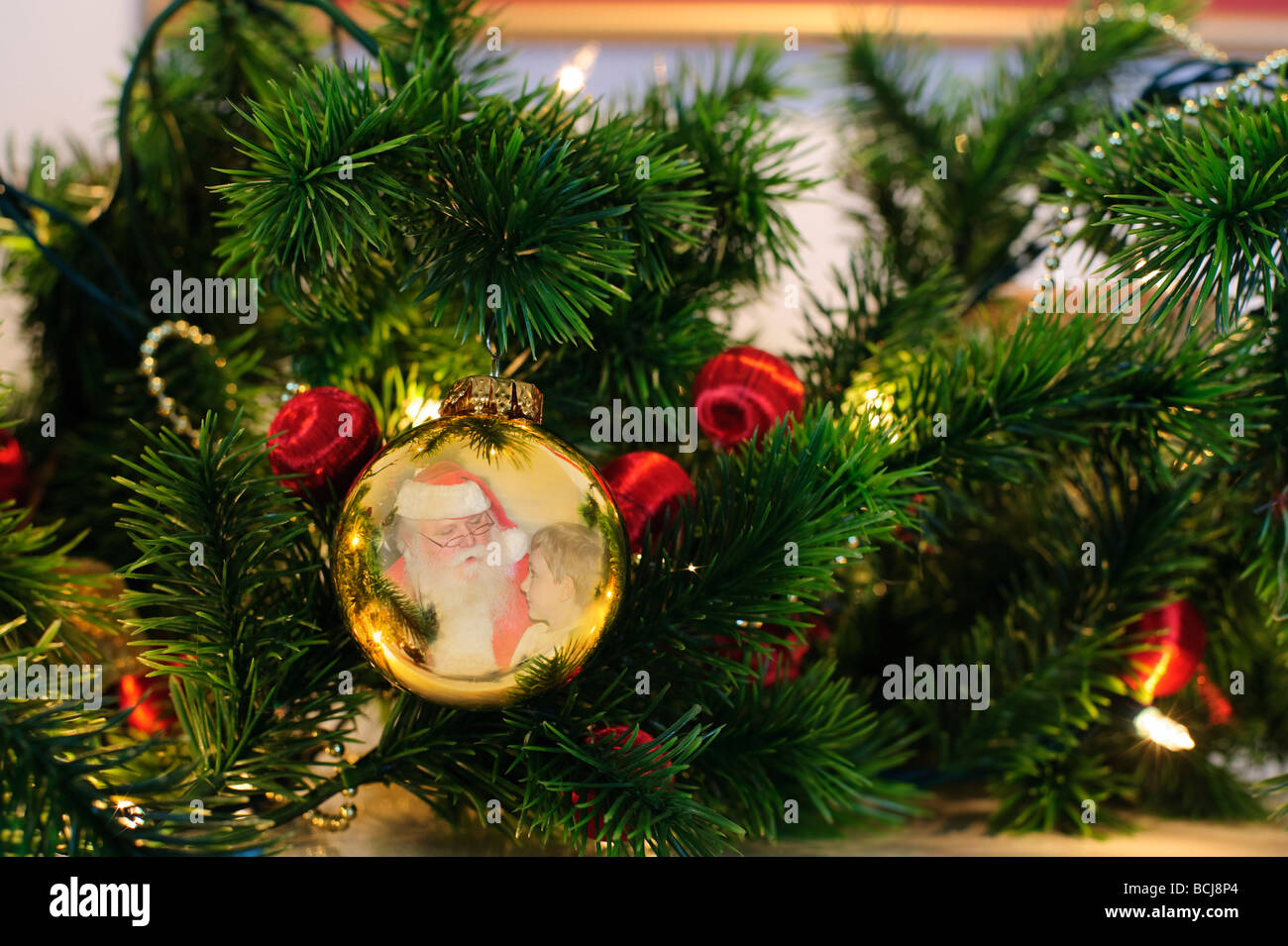 COMPOSITE Santa listens to young child reflected in a tree ornament ...