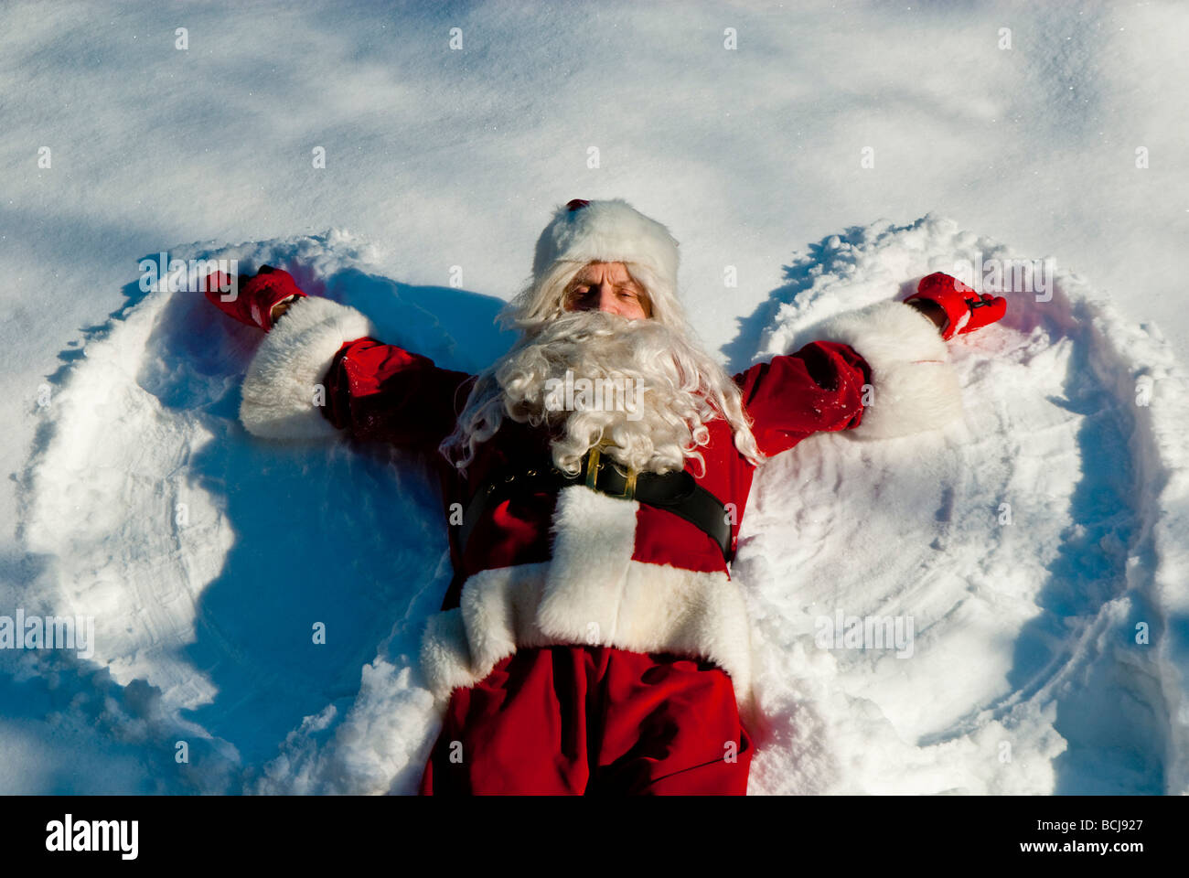 Santa making a snow angel in fresh snow Stock Photo - Alamy