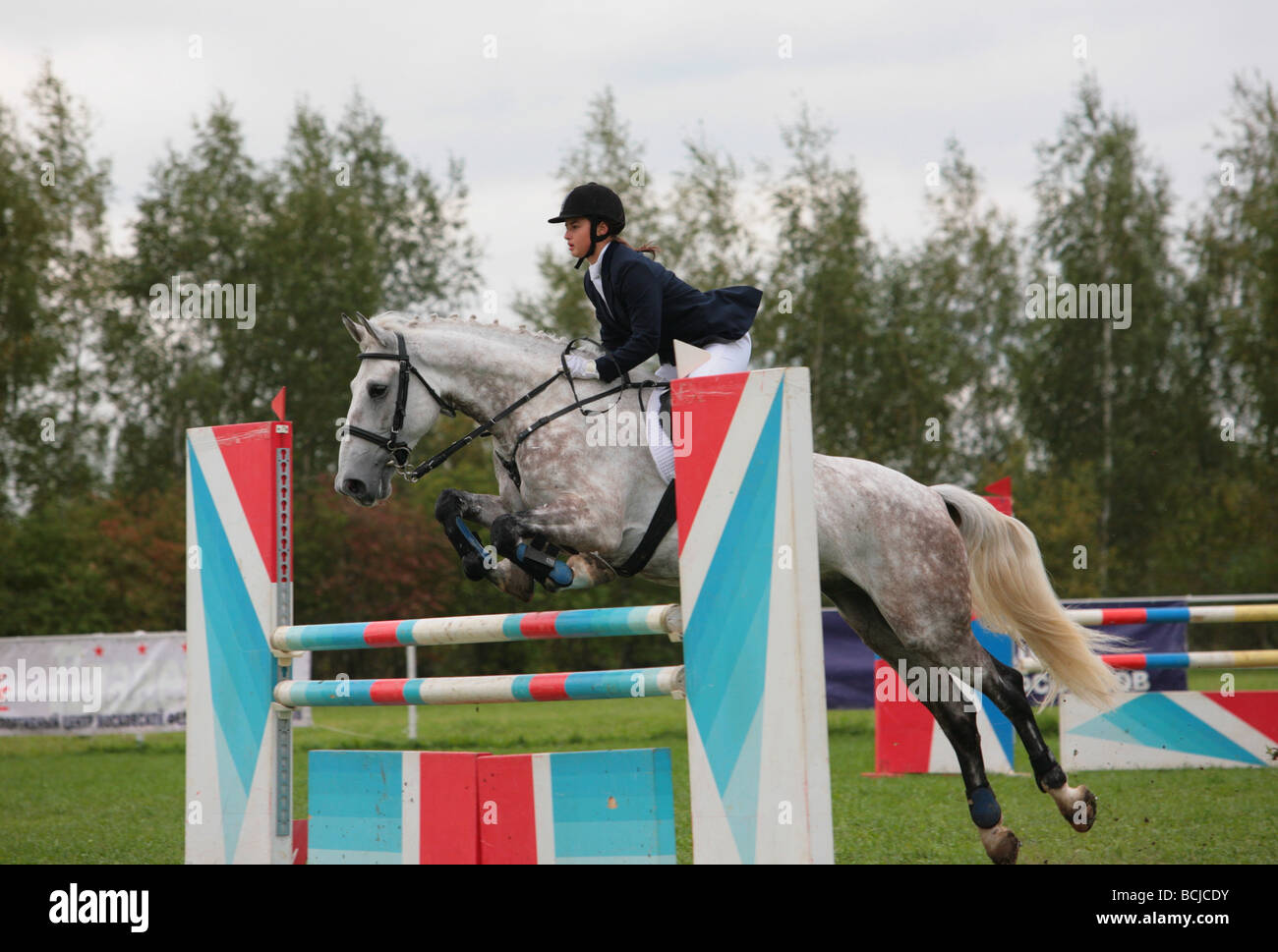 Young eventer riding in a horse jump contest Stock Photo - Alamy
