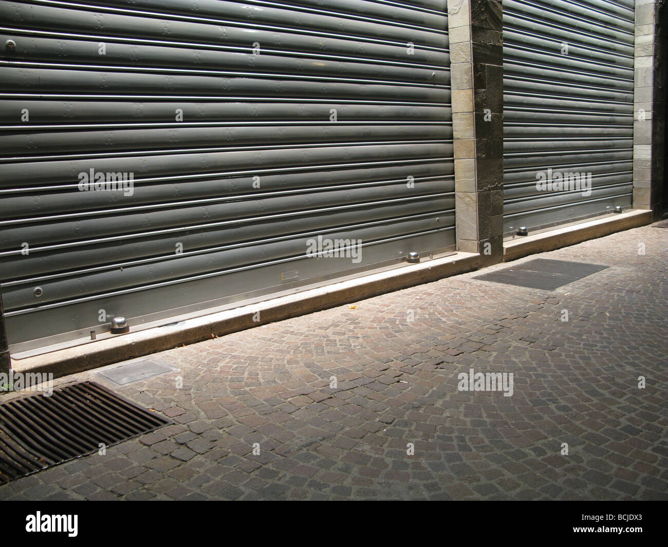 closed shop shutters in street at night Stock Photo - Alamy