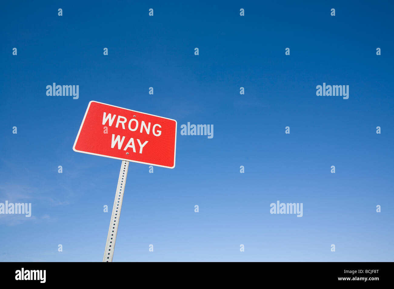 Red white WRONG WAY highway warning sign against blue sky Stock Photo ...
