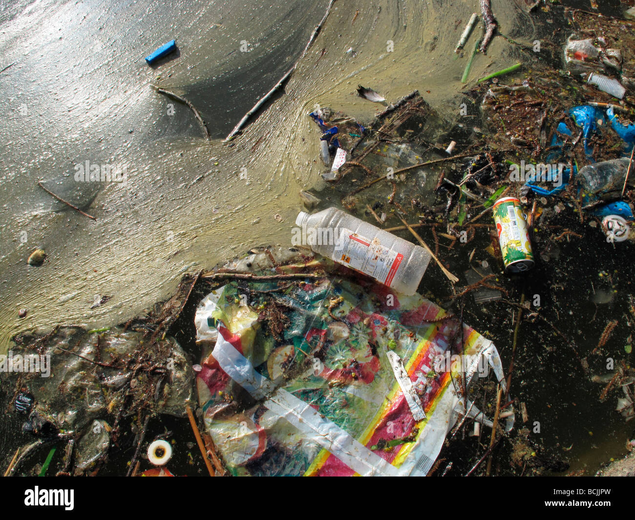Dirty plastic metal garbage rubbish floating in water Stock Photo - Alamy