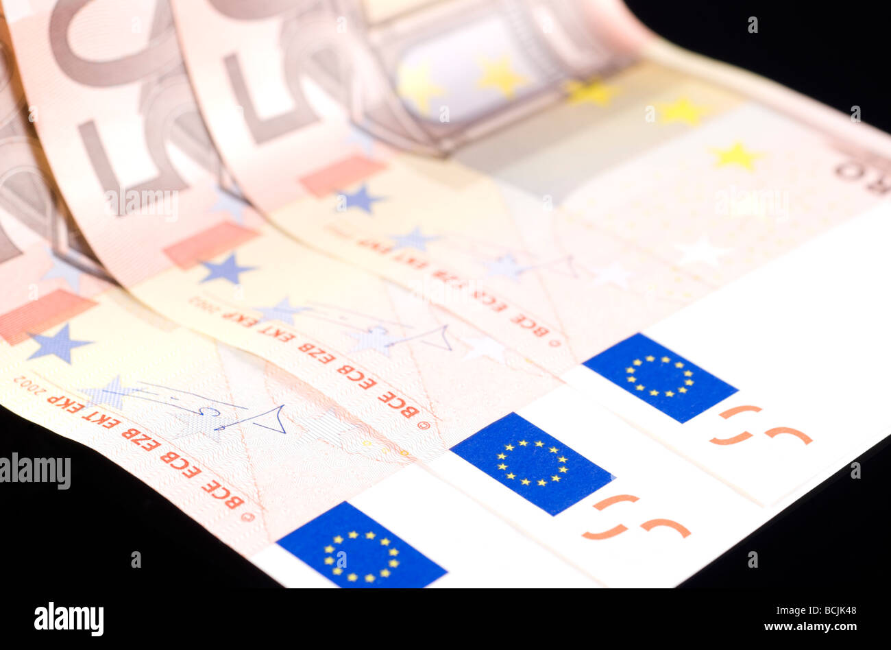 Three Euro banknotes arranged on black background Stock Photo - Alamy