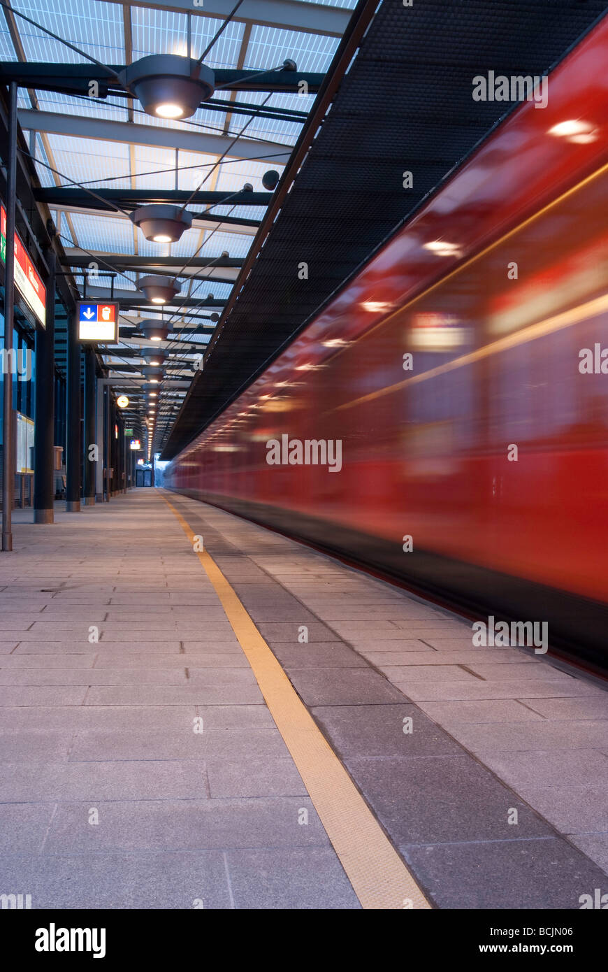 Red subway train speeding through a subway station Stock Photo - Alamy