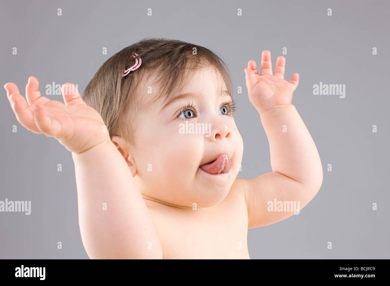 Baby with hands raised Stock Photo - Alamy