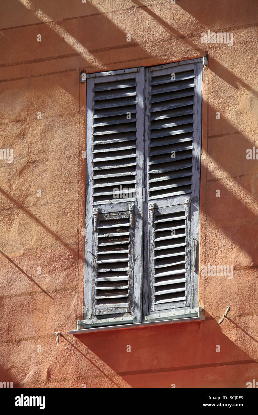 Long evening shadows across a shuttered window enhance a typical scene ...