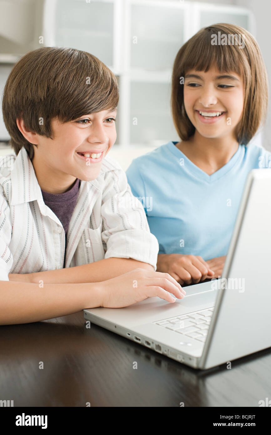 Brother and sister using a laptop computer Stock Photo - Alamy