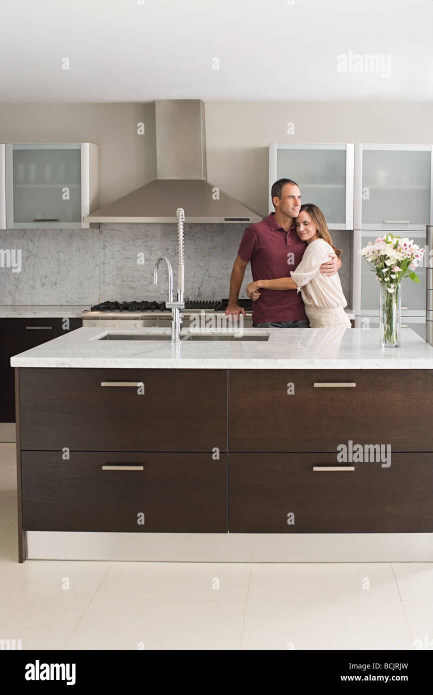 Couple hugging in kitchen Stock Photo - Alamy