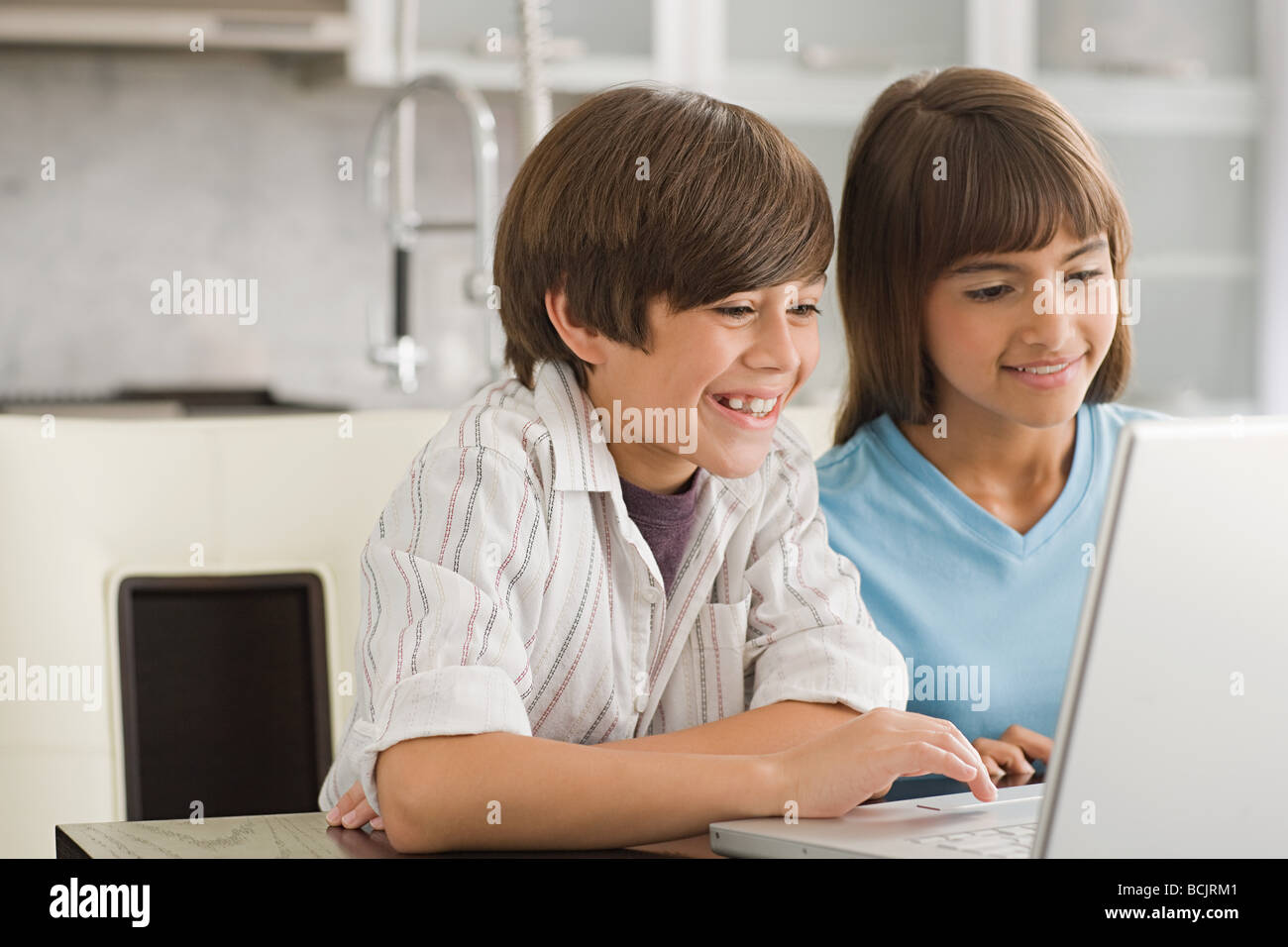 Brother and sister using a laptop computer Stock Photo - Alamy