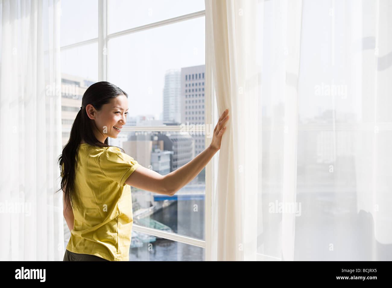 Japanese woman looking through a window Stock Photo - Alamy