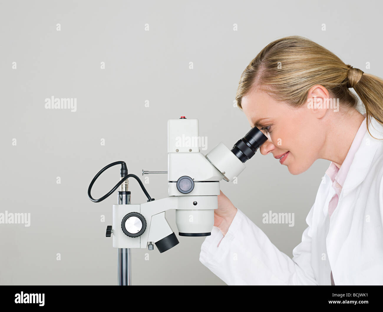 Female scientist using a microscope Stock Photo - Alamy