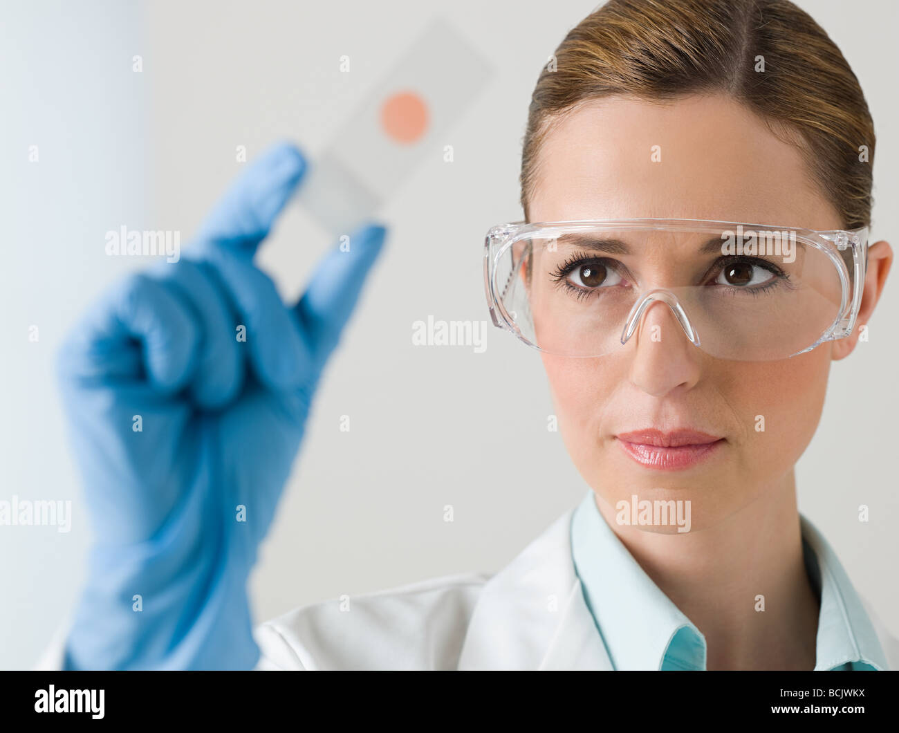 Female scientist holding litmus paper Stock Photo - Alamy