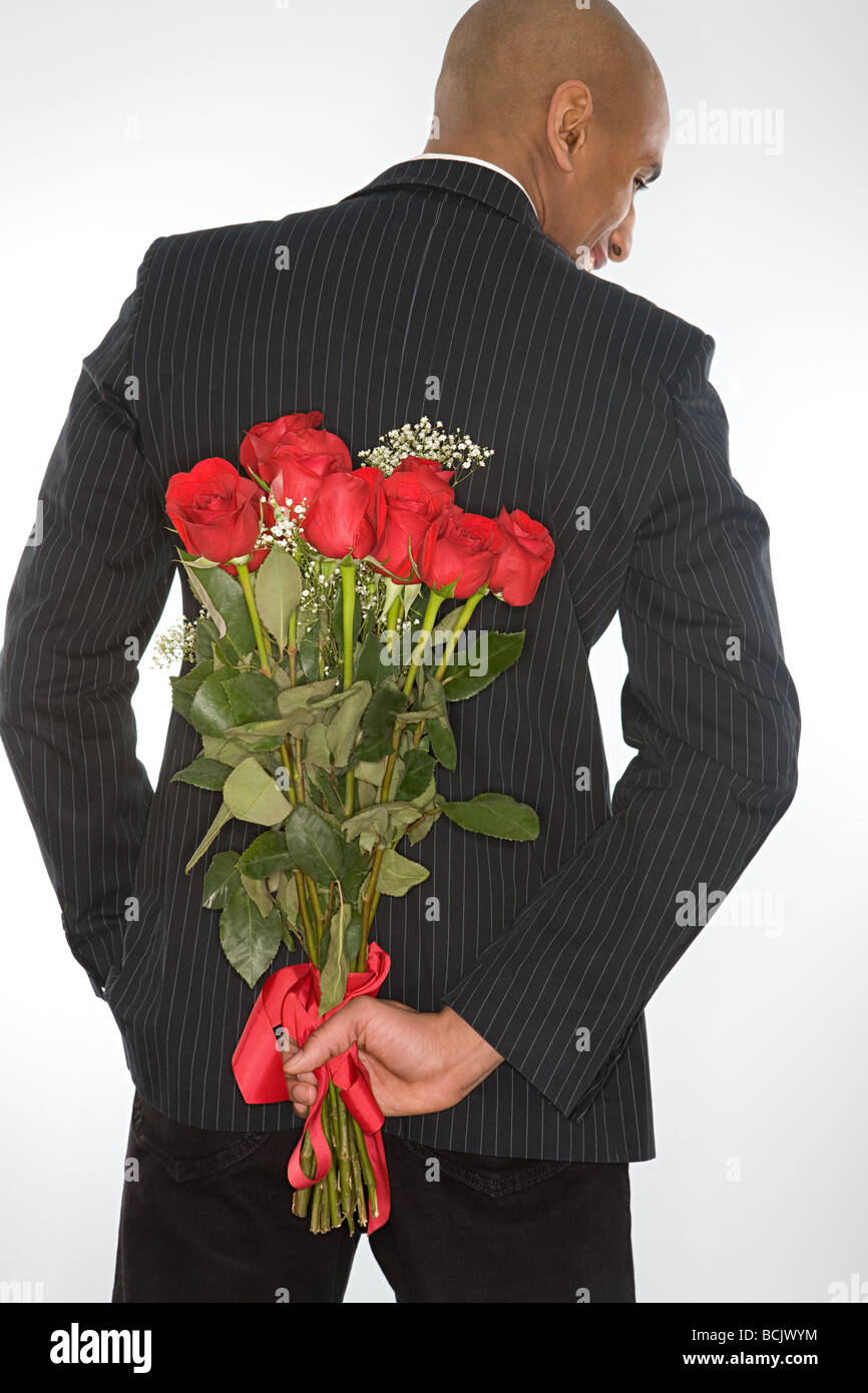 Man with a bunch of roses behind his back Stock Photo - Alamy