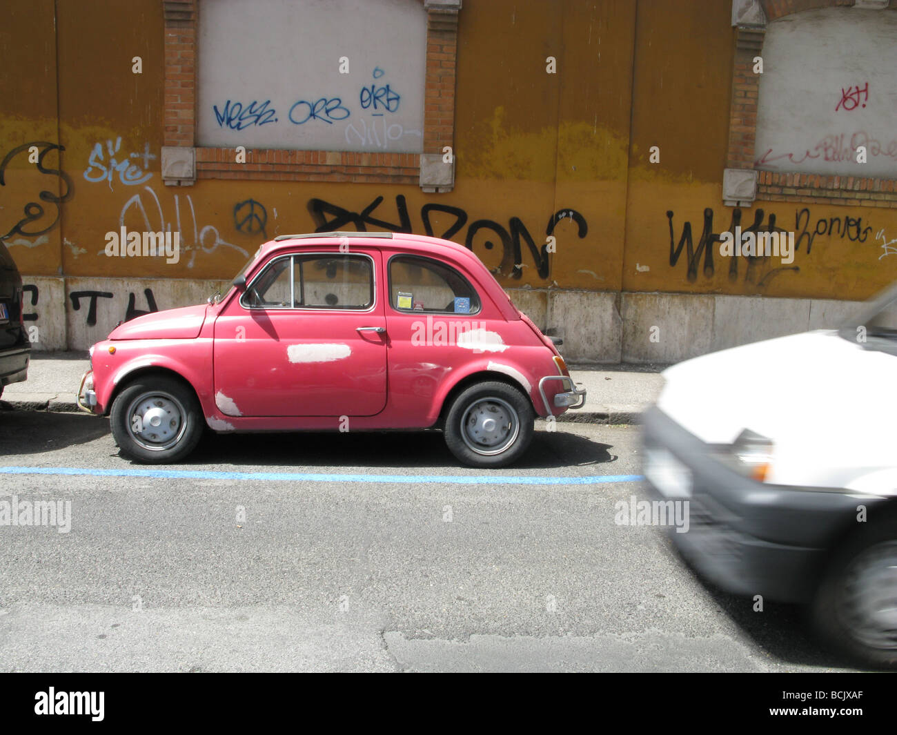 old bright pink fiat 500 in rome italy Stock Photo - Alamy